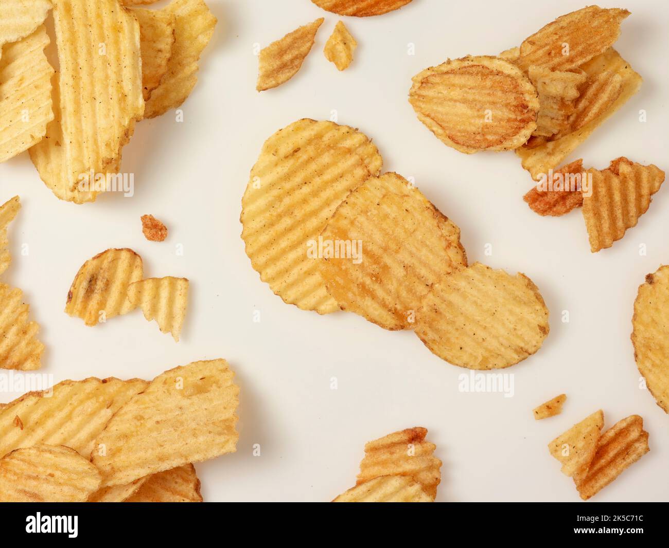 Clean background crinkle cut potato crisps in close up, food snack ...