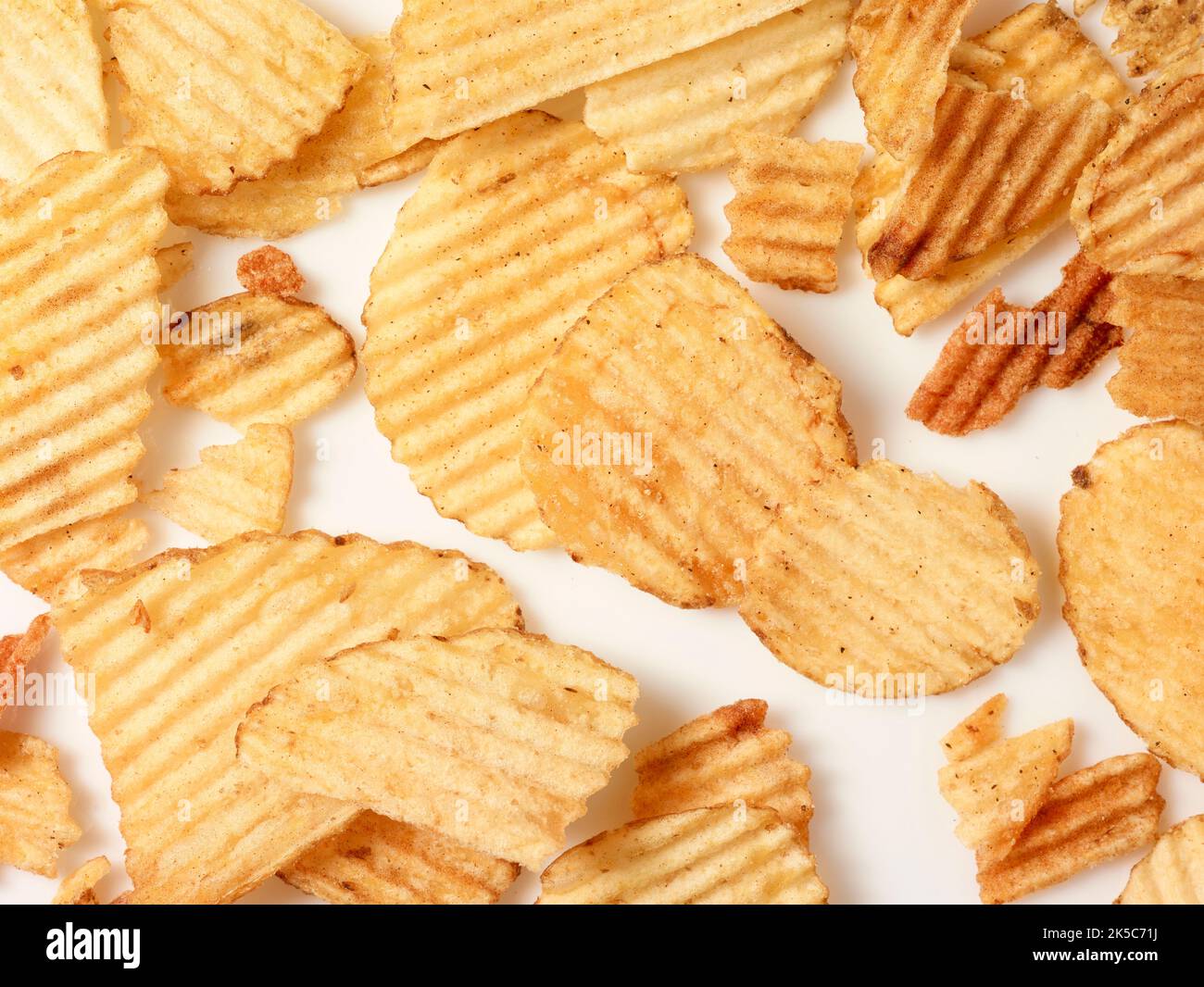 Clean background crinkle cut potato crisps in close up, food snack ...