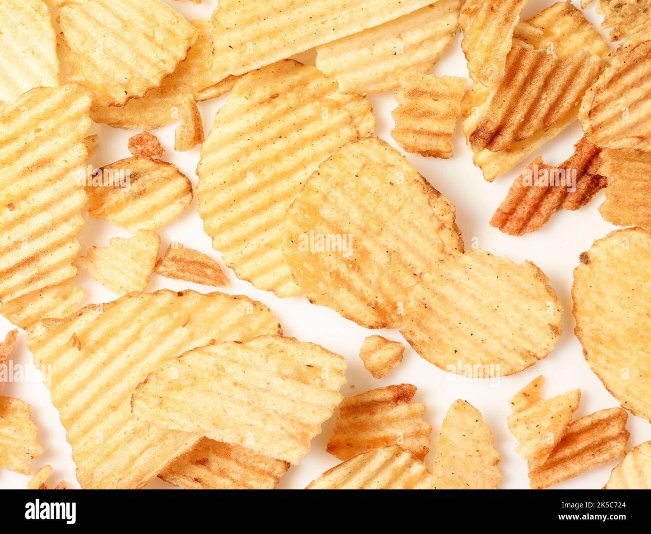 Clean background crinkle cut potato crisps in close up, food snack ...