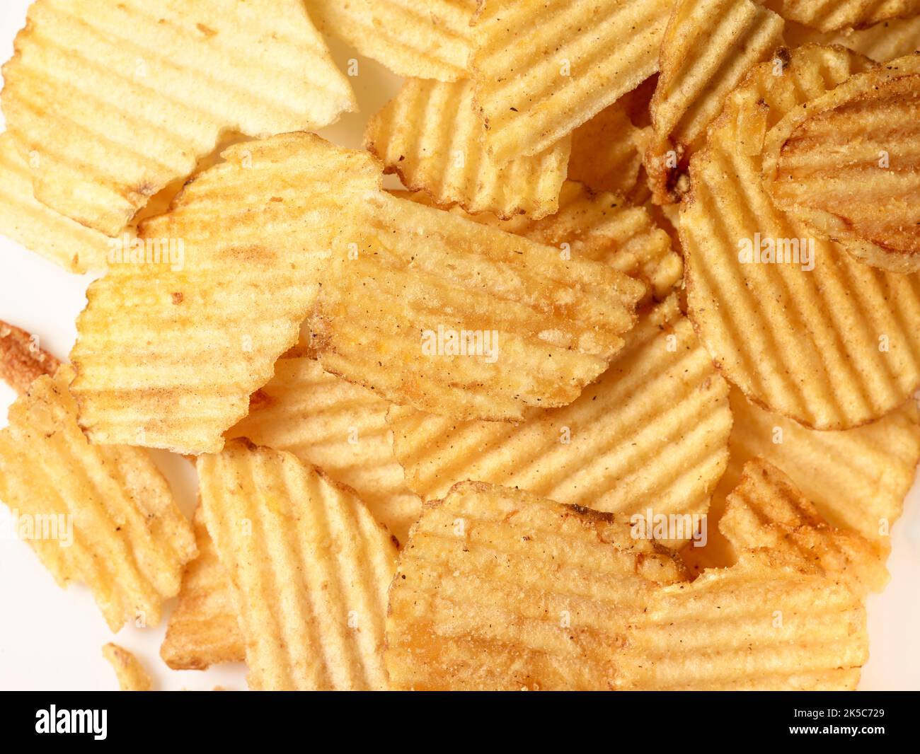 Clean background crinkle cut potato crisps in close up, food snack ...