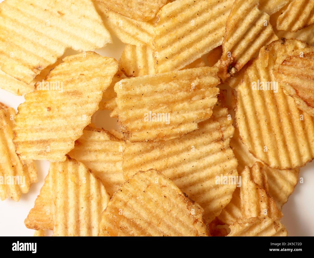 Clean background crinkle cut potato crisps in close up, food snack ...