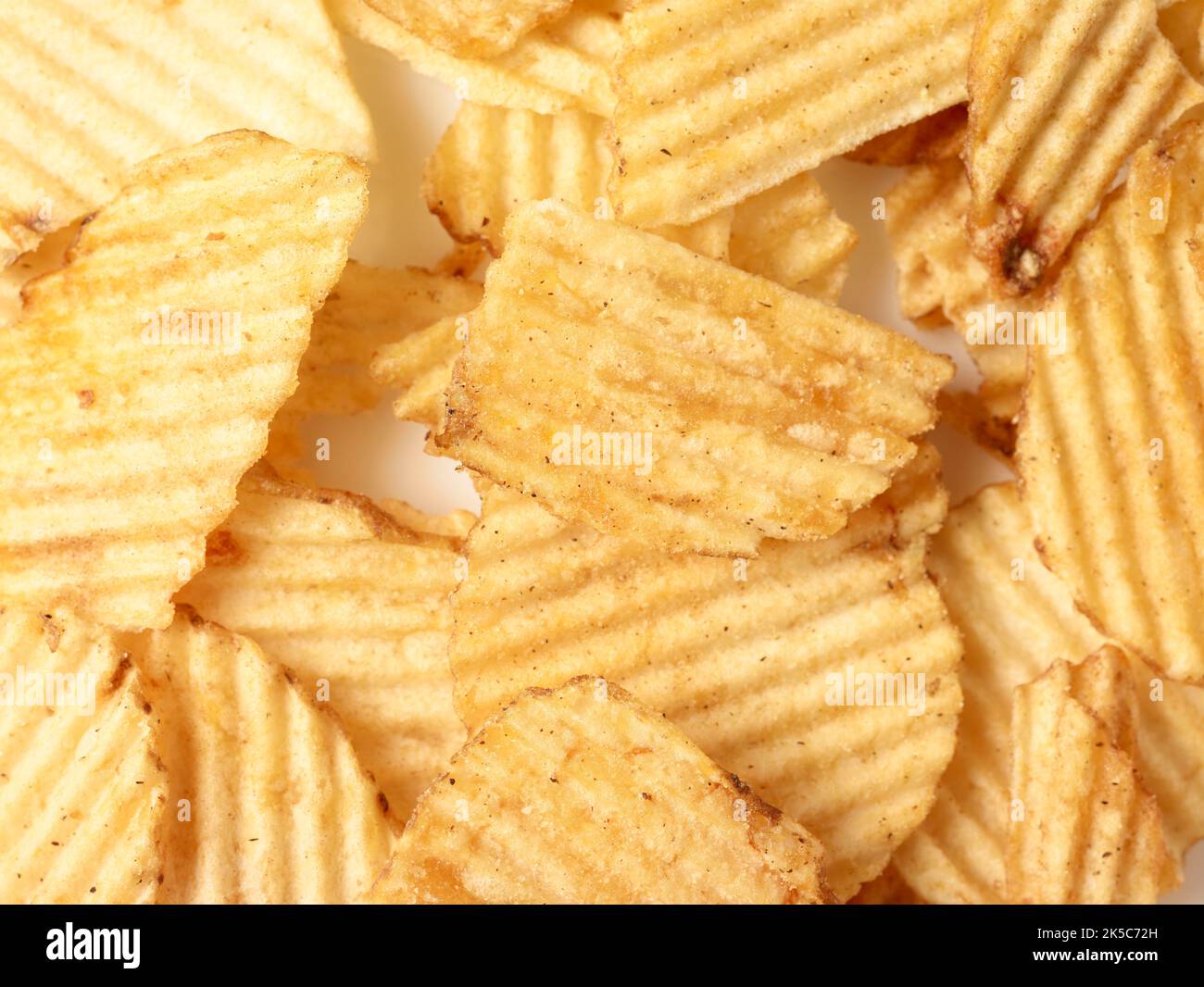 Clean background crinkle cut potato crisps in close up, food snack ...