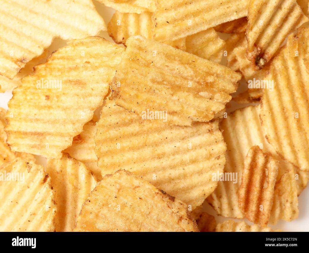 Clean background crinkle cut potato crisps in close up, food snack ...