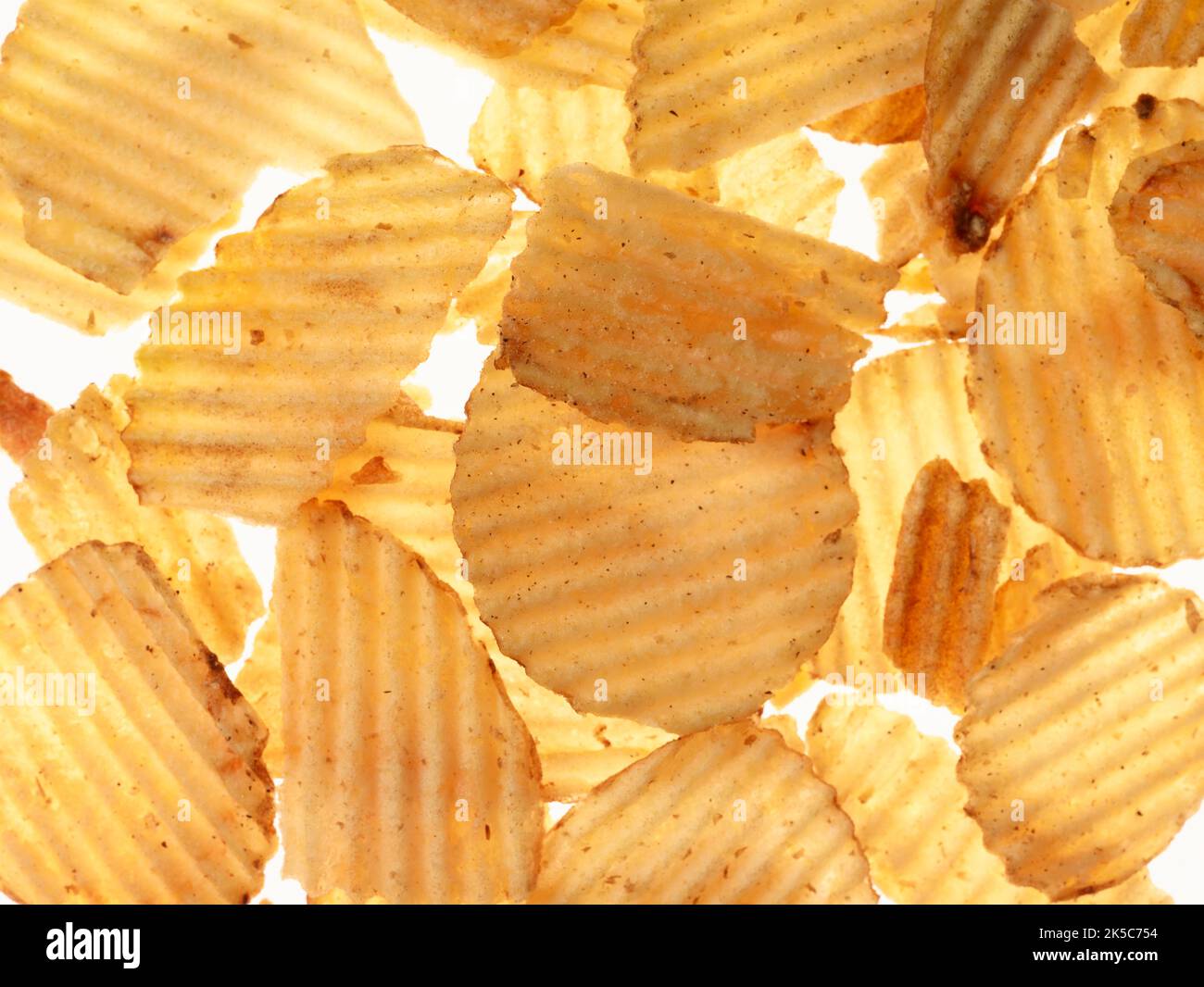 Clean background crinkle cut potato crisps in close up, food snack ...