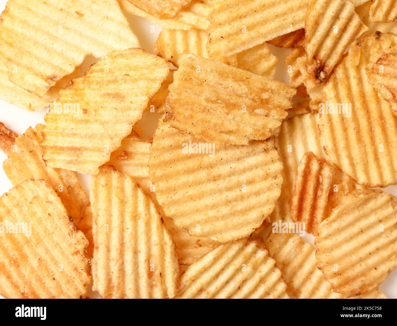 Clean background crinkle cut potato crisps in close up, food snack ...