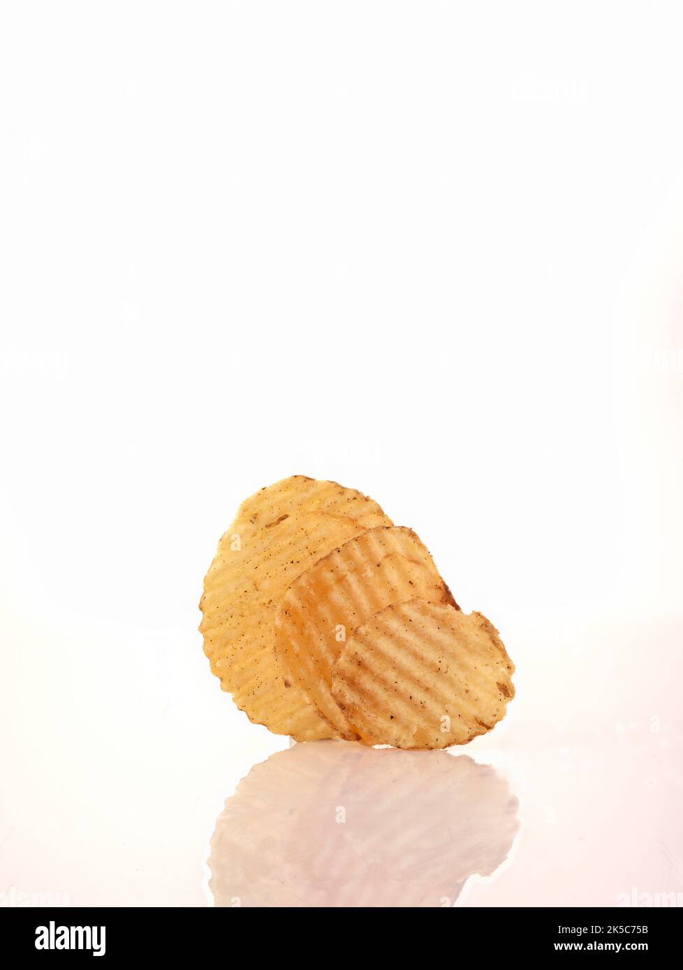Clean background crinkle cut potato crisps in close up, food snack ...