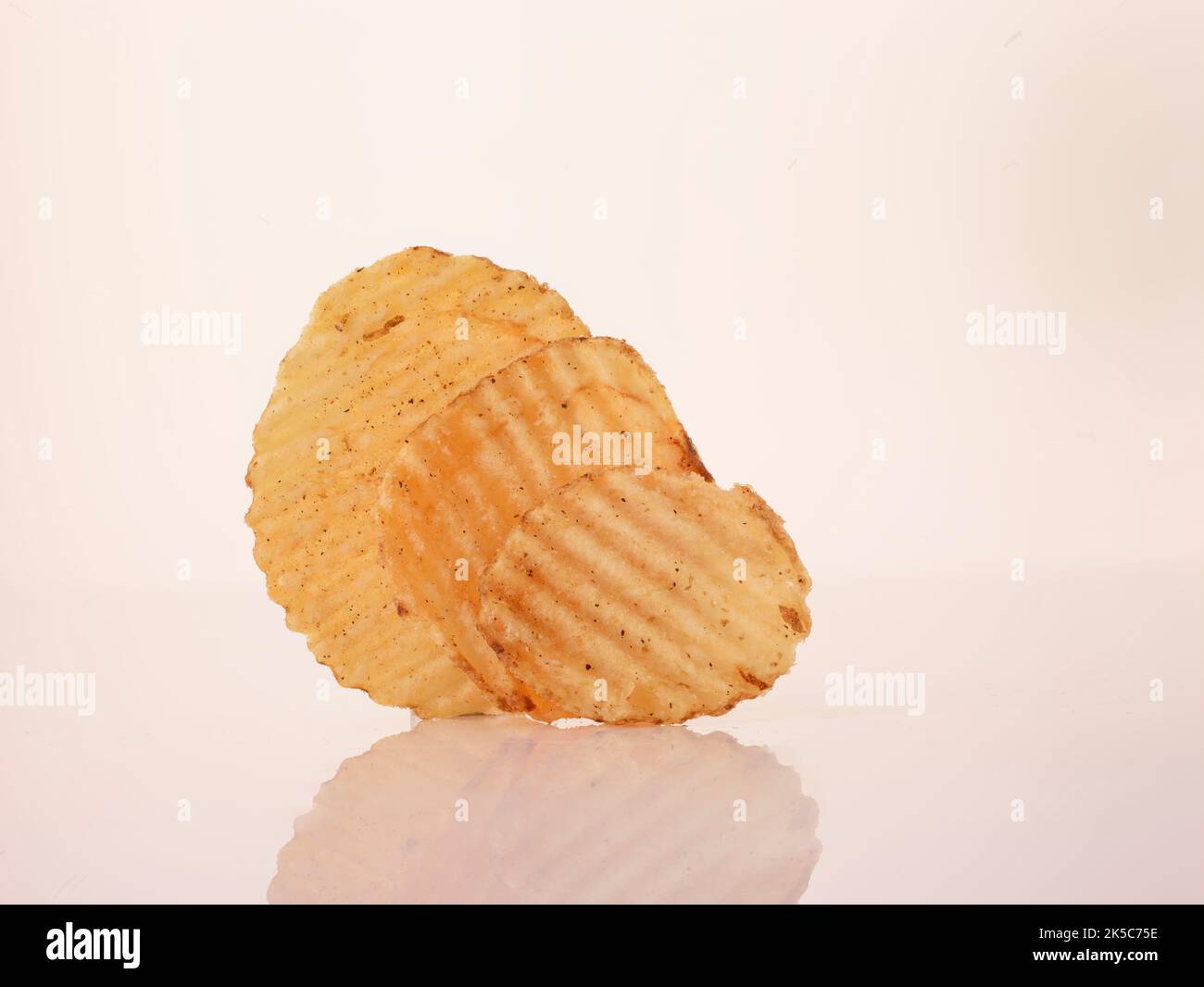 Clean background crinkle cut potato crisps in close up, food snack ...