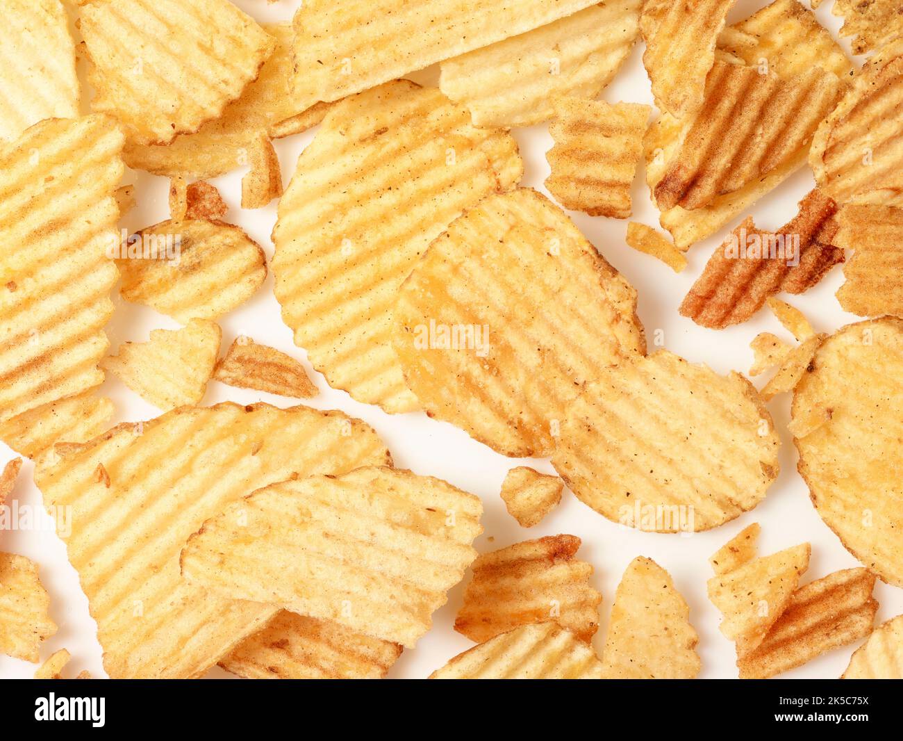 Clean background crinkle cut potato crisps in close up, food snack ...