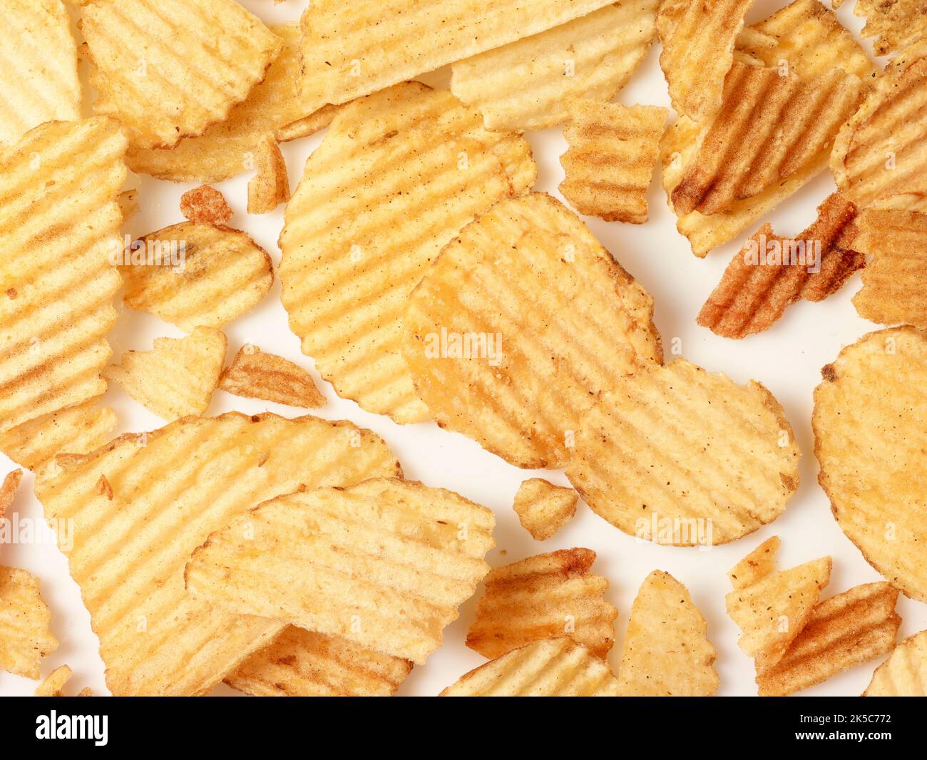 Clean background crinkle cut potato crisps in close up, food snack ...