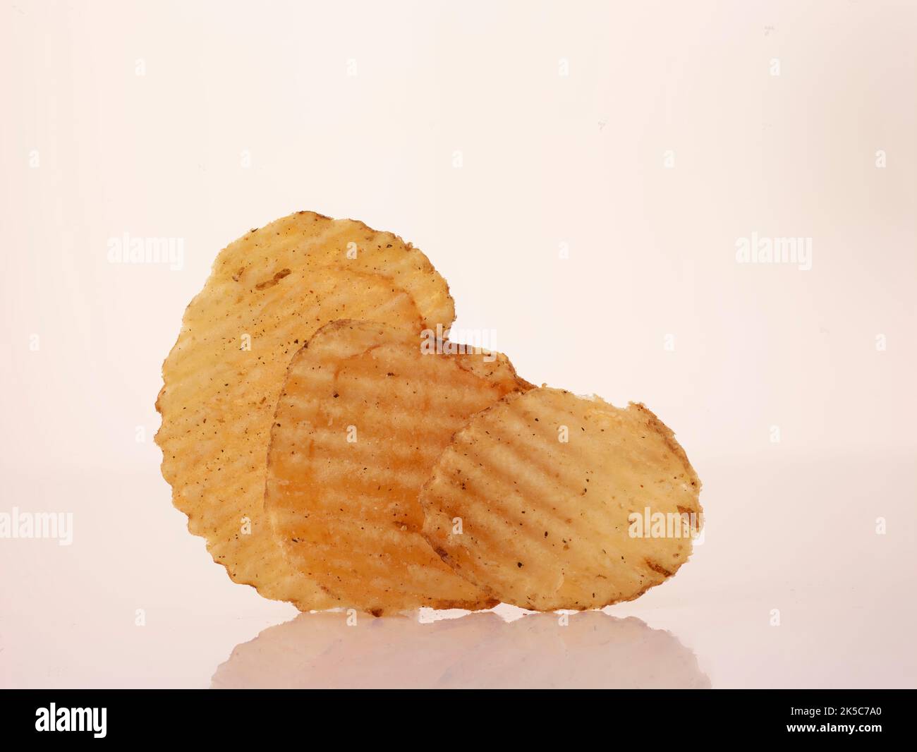 Clean background crinkle cut potato crisps in close up, food snack ...