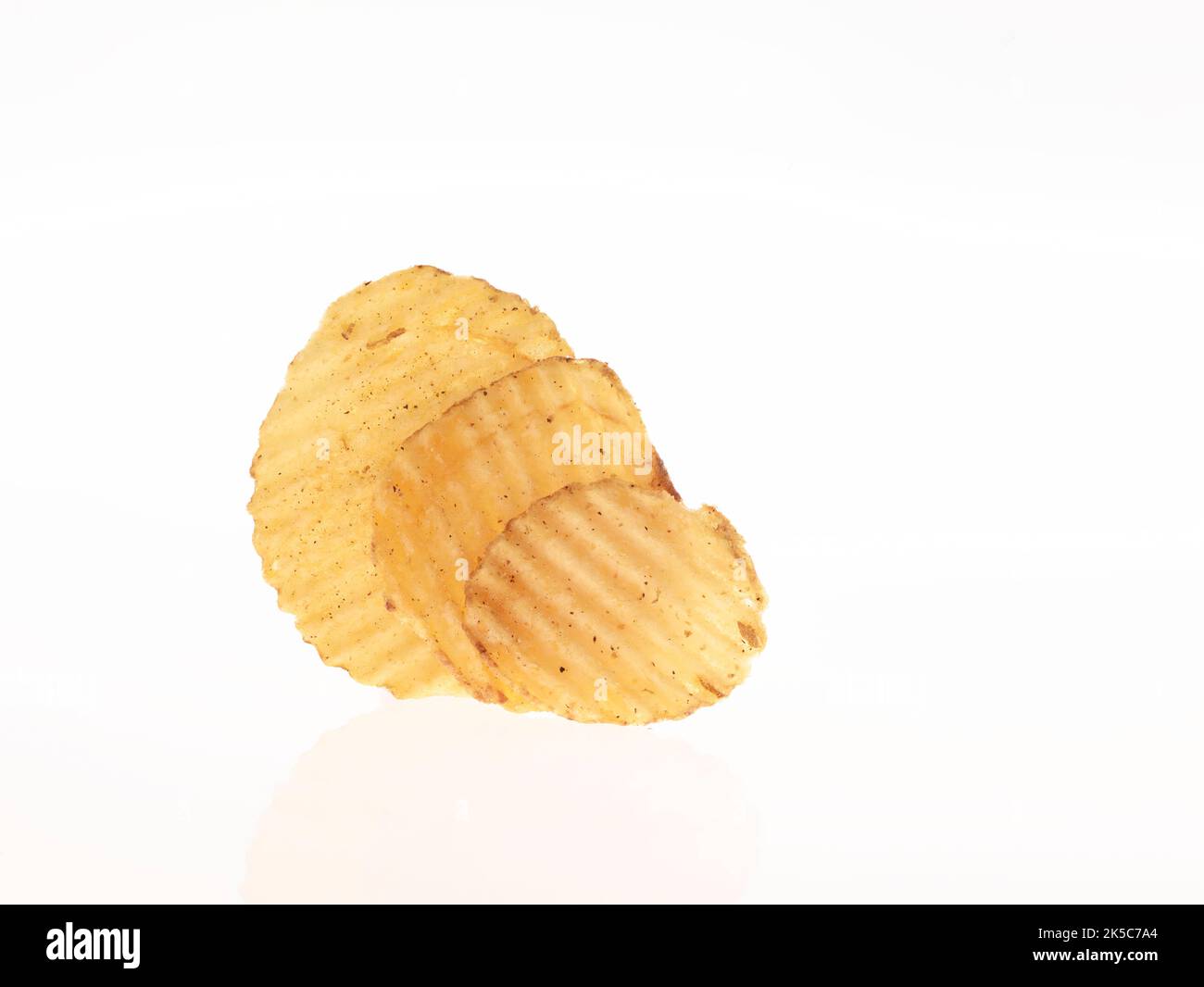 Food snack still-life of Crinkle cut crisps on plain background Stock ...