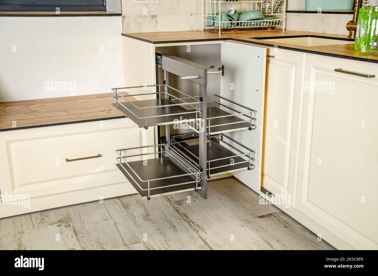 Retractable metal shelves in kitchen furniture Stock Photo - Alamy