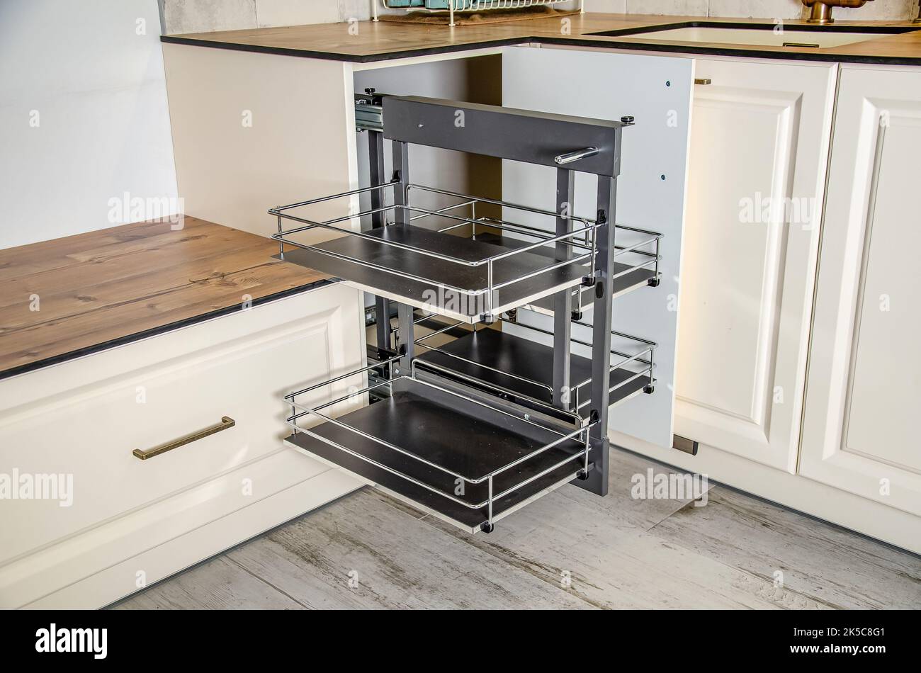 Retractable metal shelves in kitchen furniture Stock Photo - Alamy