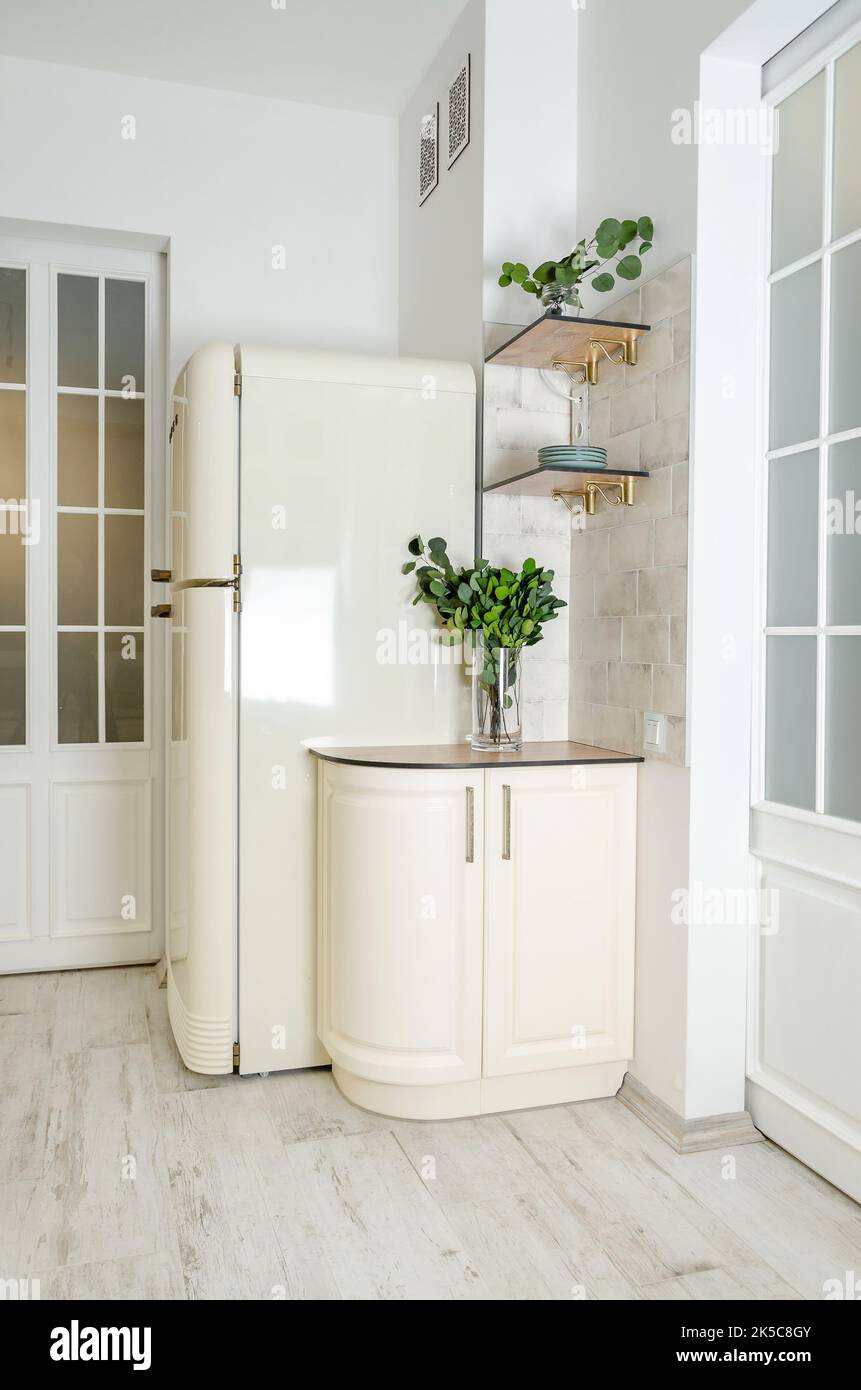 White corner bedside table and cream-colored white refrigerator in the ...