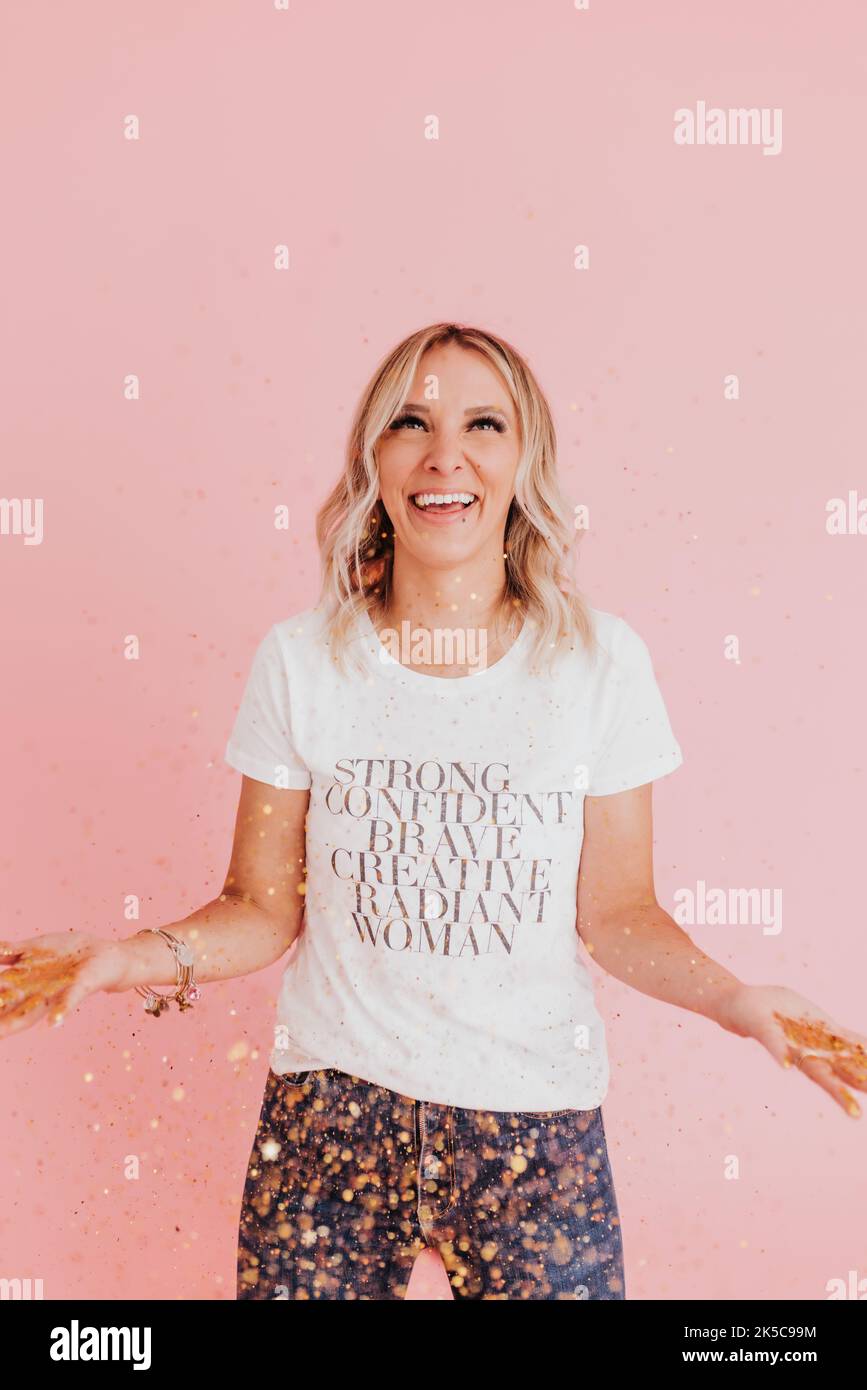 standing woman laughs while throwing gold glitter Stock Photo - Alamy