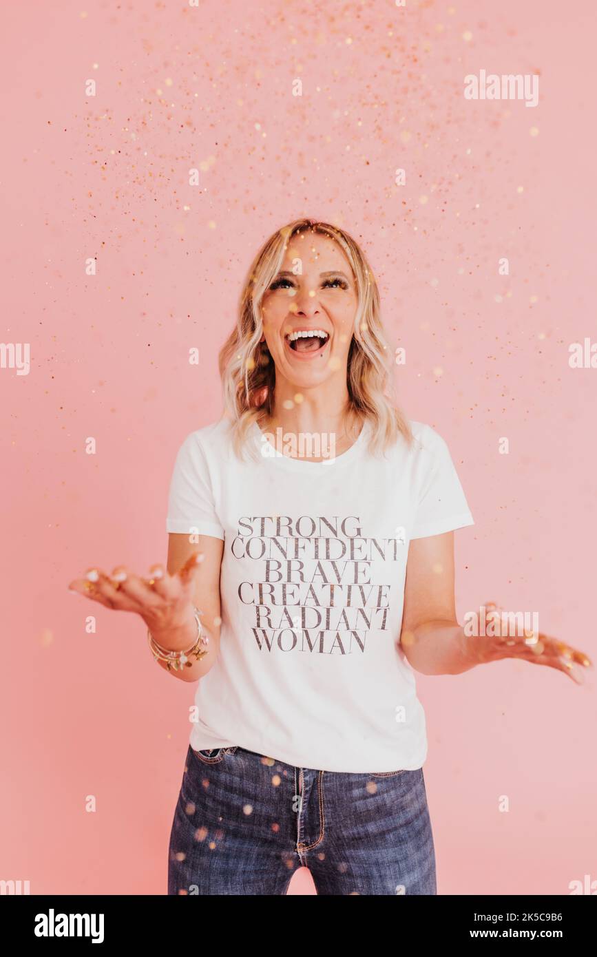 standing woman laughs while throwing gold glitter Stock Photo - Alamy