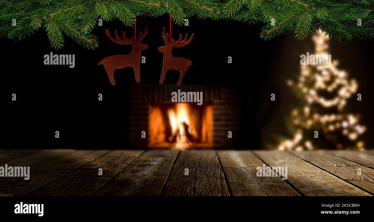 Two decorative reindeer on a fir branch in front of fireplace fire ...