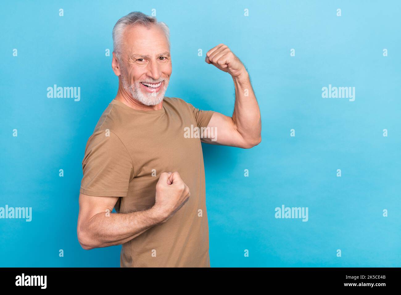 Portrait of attractive funny old man show arm demonstrate biceps wear ...