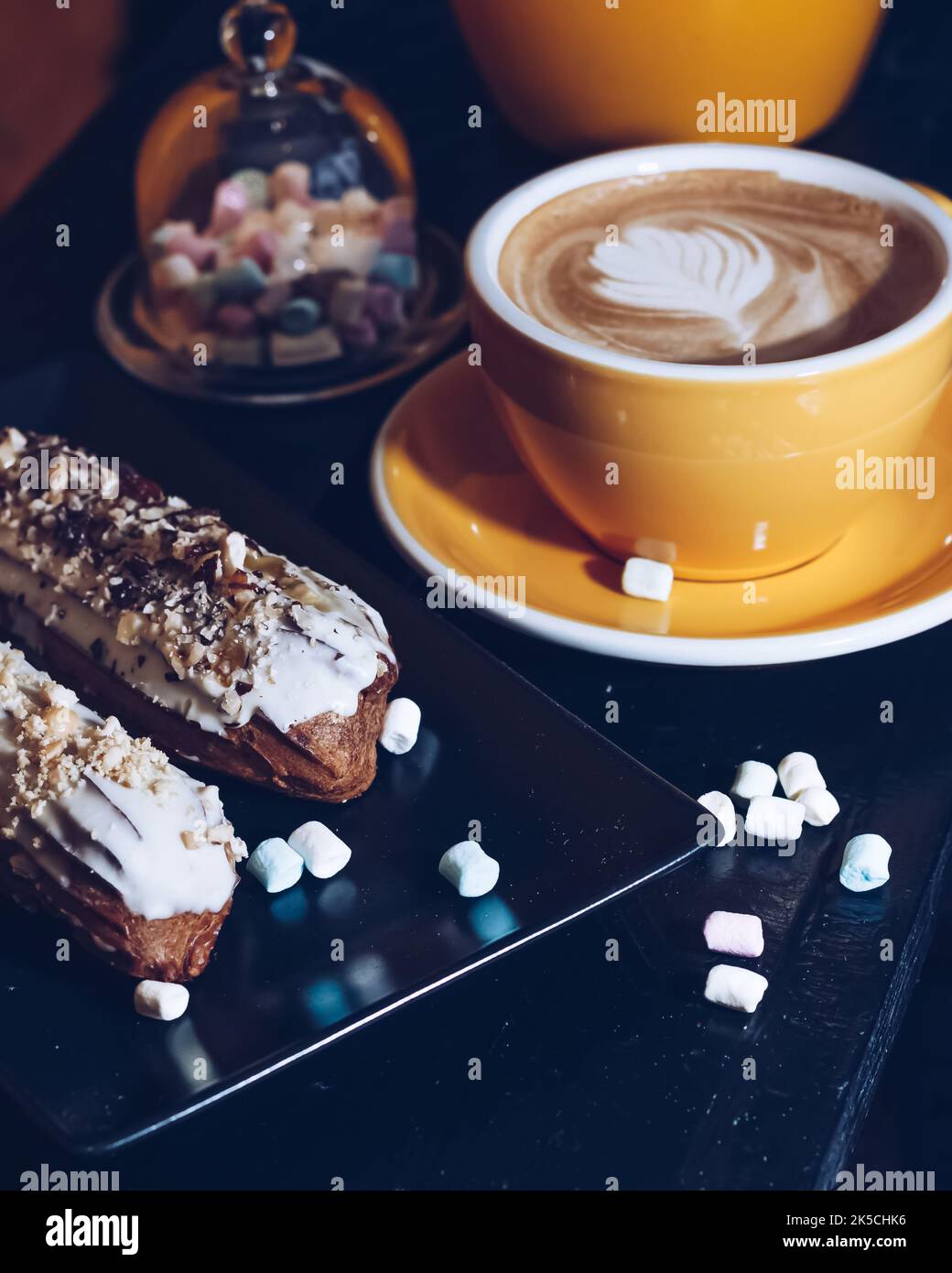 Traditional French dessert eclair with white chocolate, coffee cup and ...