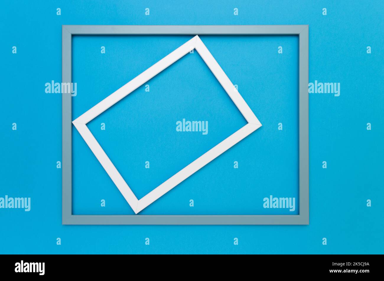 A White frame rotated in a light blue frame on a vibrant blue ...
