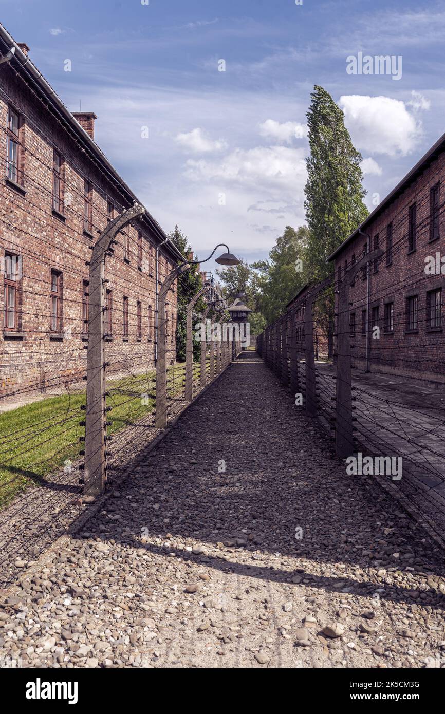 A vertical shot of a narrow path between buildings with barbed wire ...