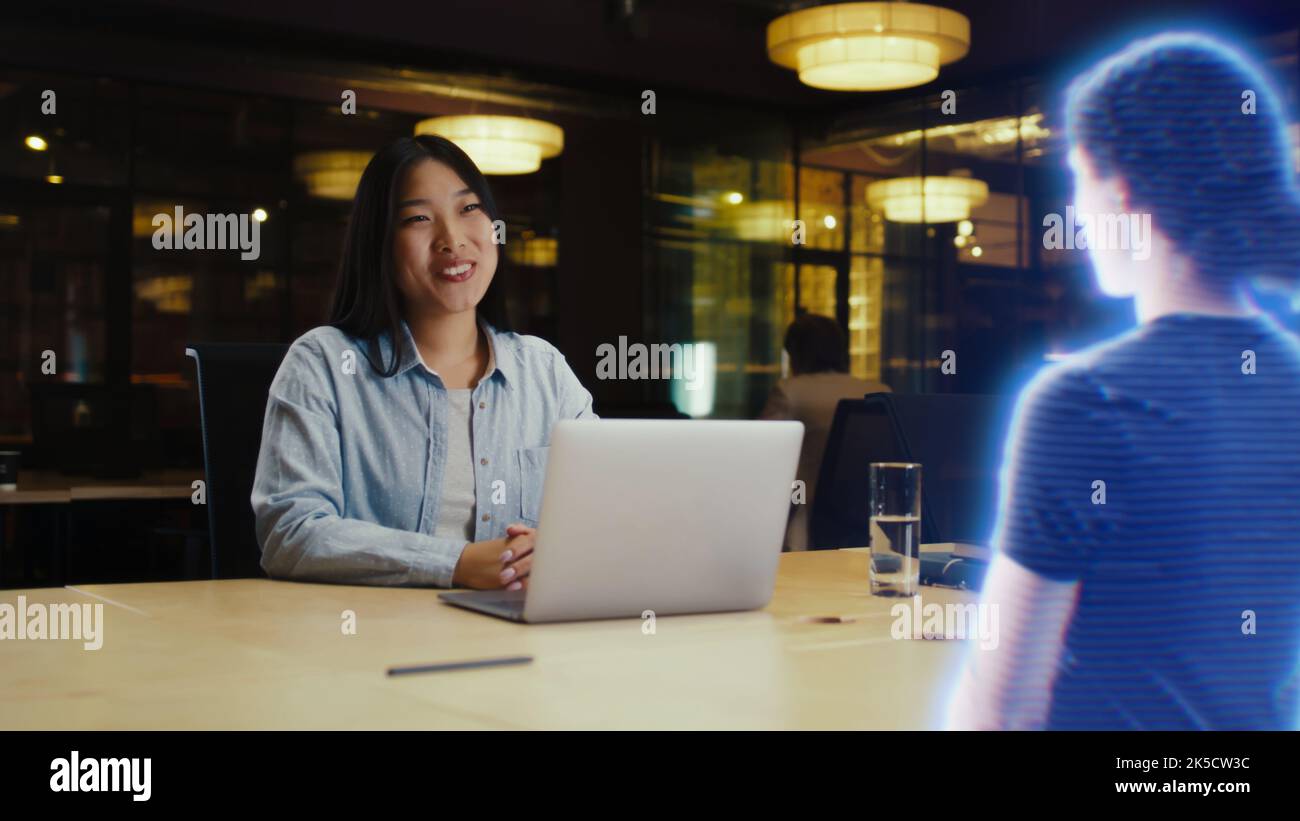 Young asian woman receives a call via an abstract futuristic screen ...
