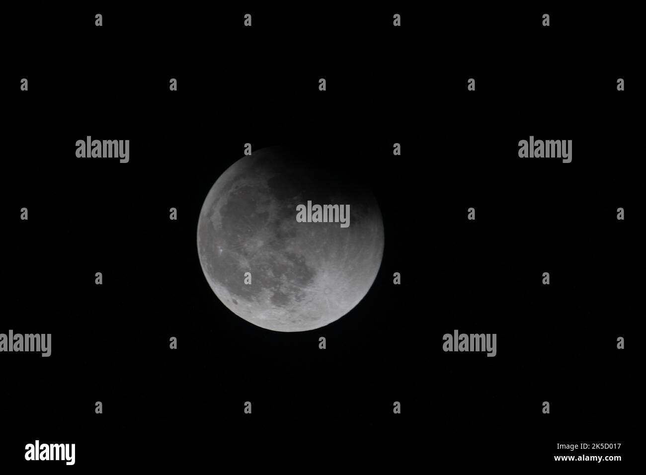 The Moon, with Earth's shadow draping across it during a lunar eclipse ...