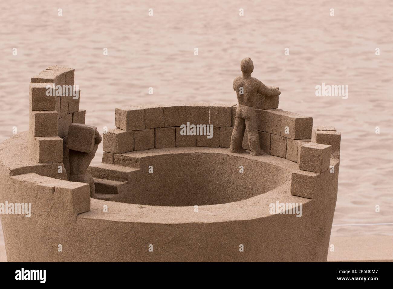 Sand man building a sand castle. Concept Idea or business growing Stock ...