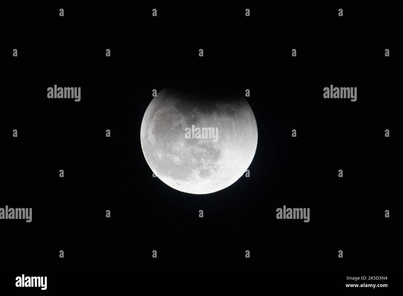 The Moon, with Earth's shadow draping across it during a lunar eclipse ...