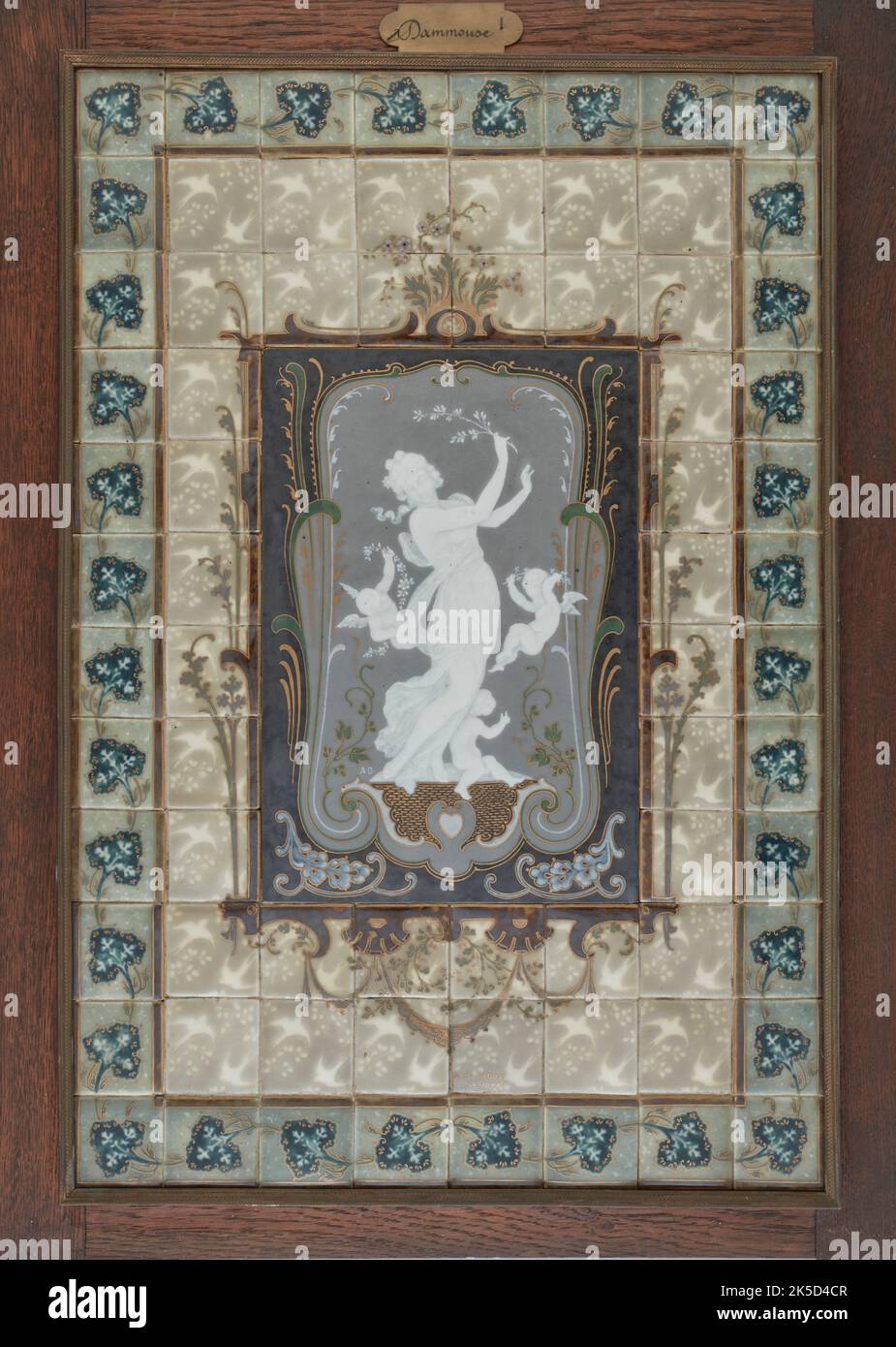 Porcelain tiled panel surrounding a central plaque showing a woman and ... Porcelain tiled panel surrounding a central plaque showing a woman and ...
