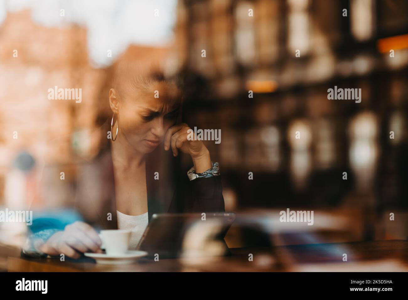 woman in a coffee shop drink coffee viewed through glass with ...