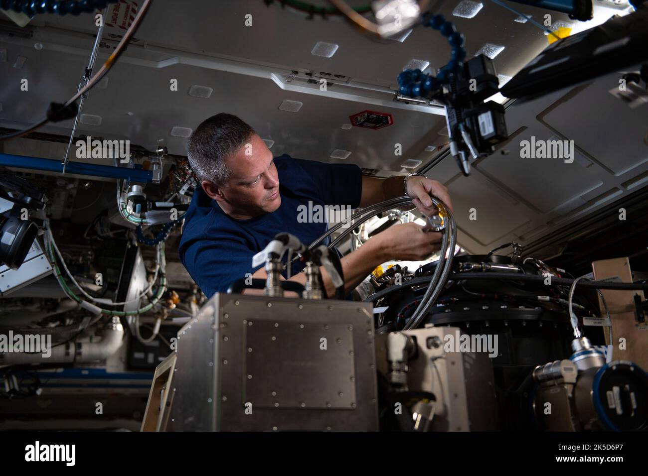 NASA astronaut Bob Hines works on the Combustion Integrated Rack during ...