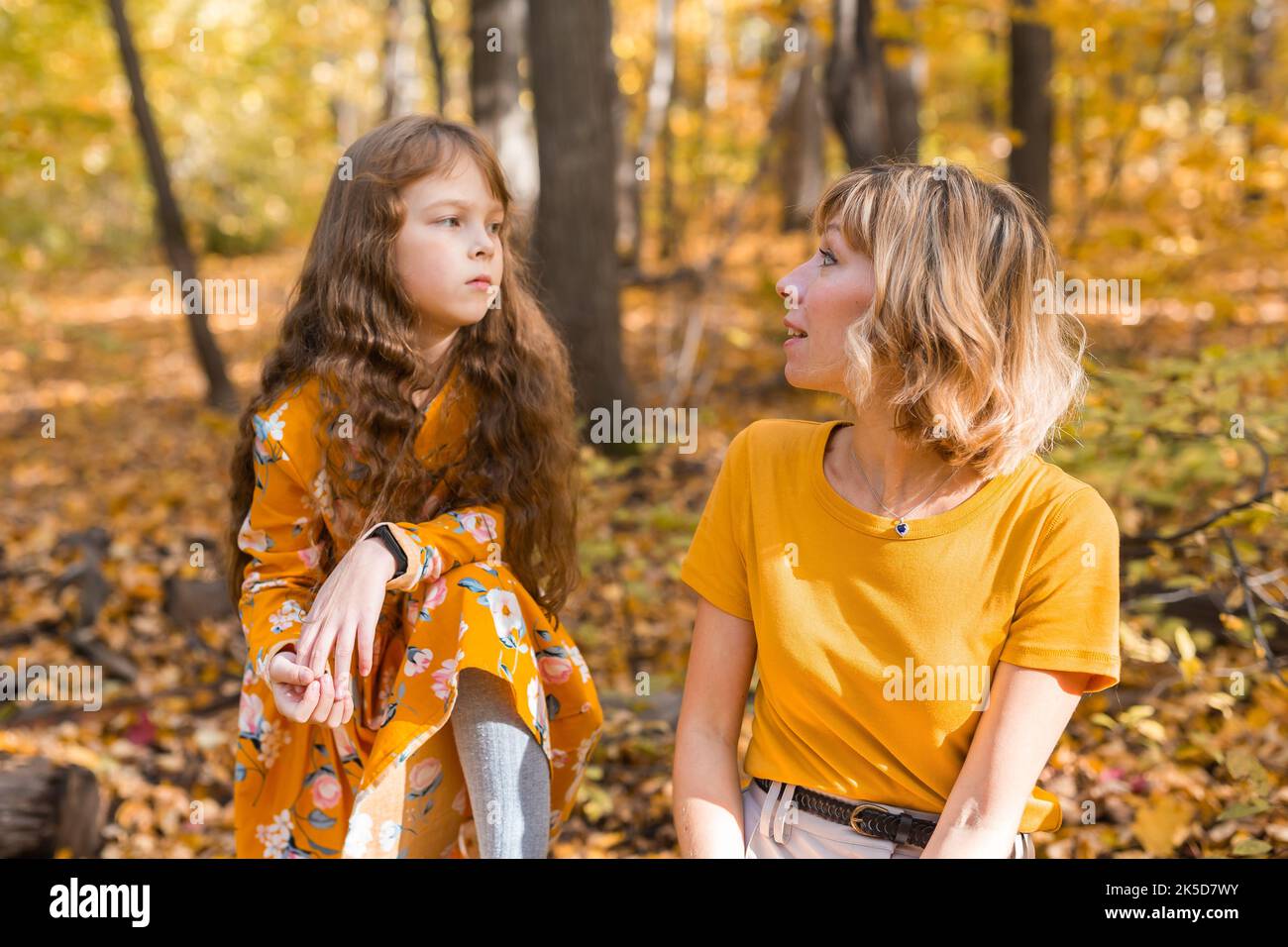 Mother soothes her unhappy sad daughter in autumn nature. Children ...