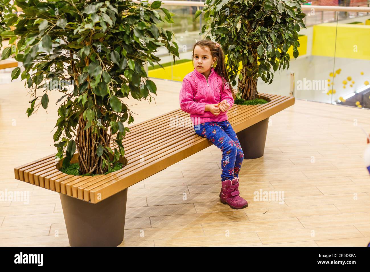 Little girl alone in shopping mall center, looking for her mother. The ...