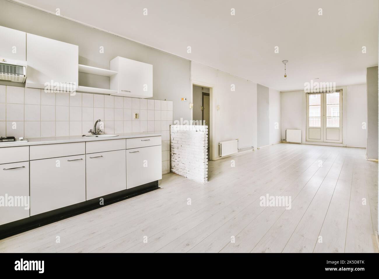 Interior of empty white kitchen with windows and wooden parquet floor ...