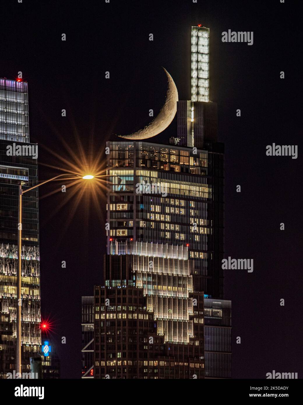 A vertical shot of Crescent moon setting behind Comcast Technology ...