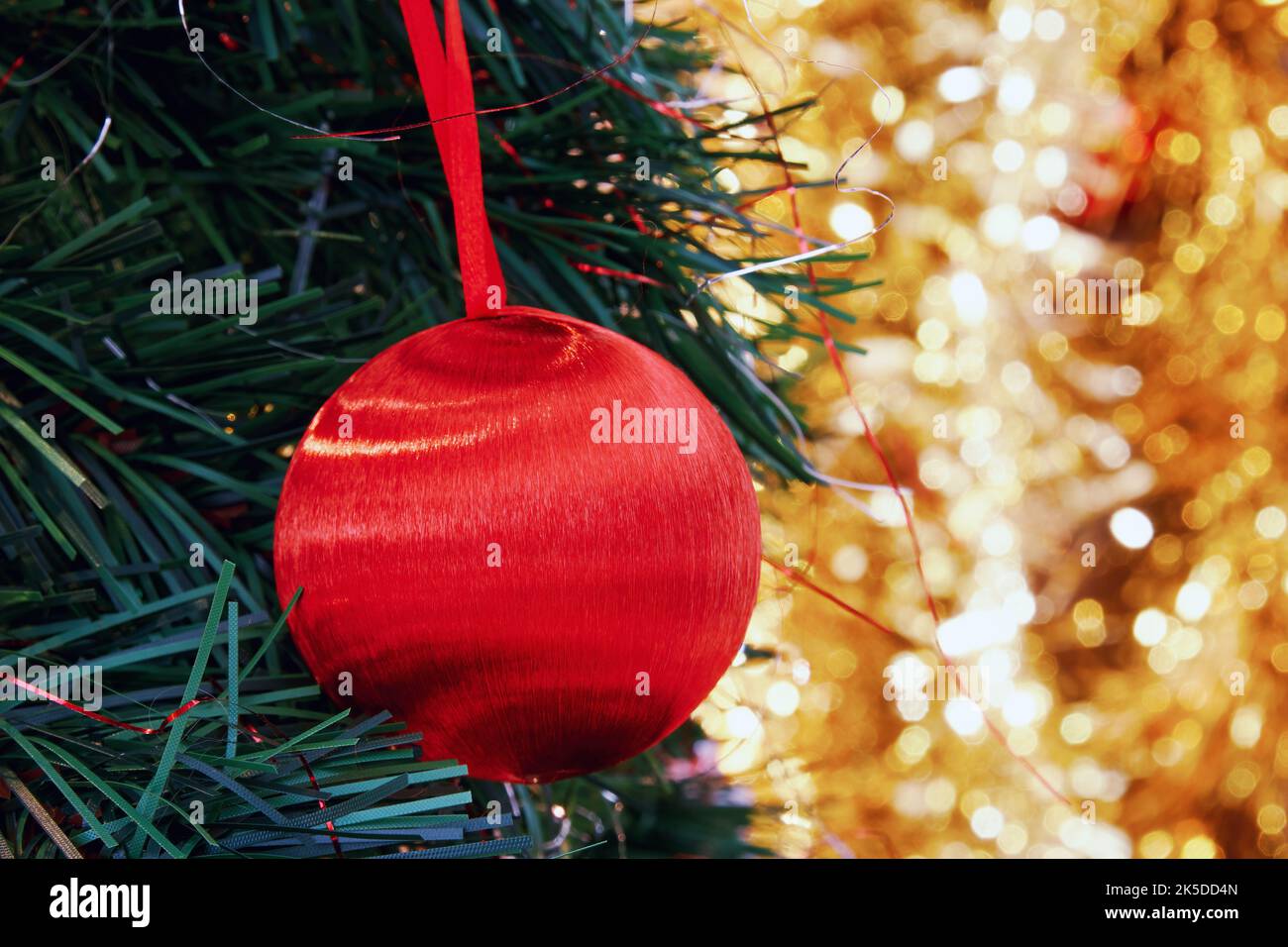 Bright red Christmas tree toy on the fir branch in interior. New Year ...