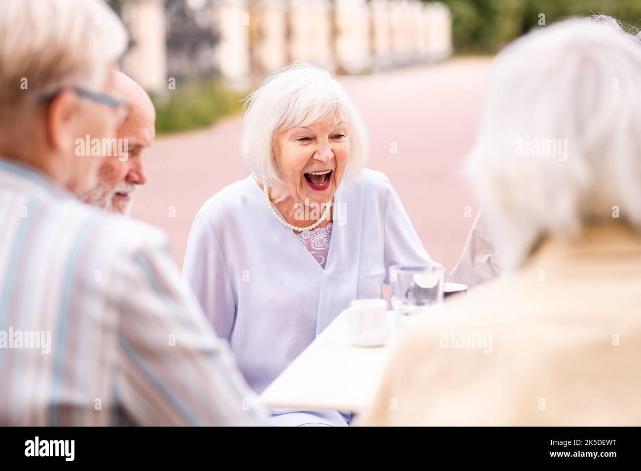 Group of happy elderly people bonding outdoors at the bar cafeteria ...