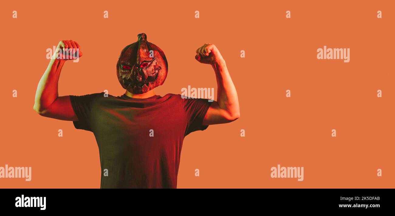 A man with a scary pumpkin mask is raising his fists - Halloween ...