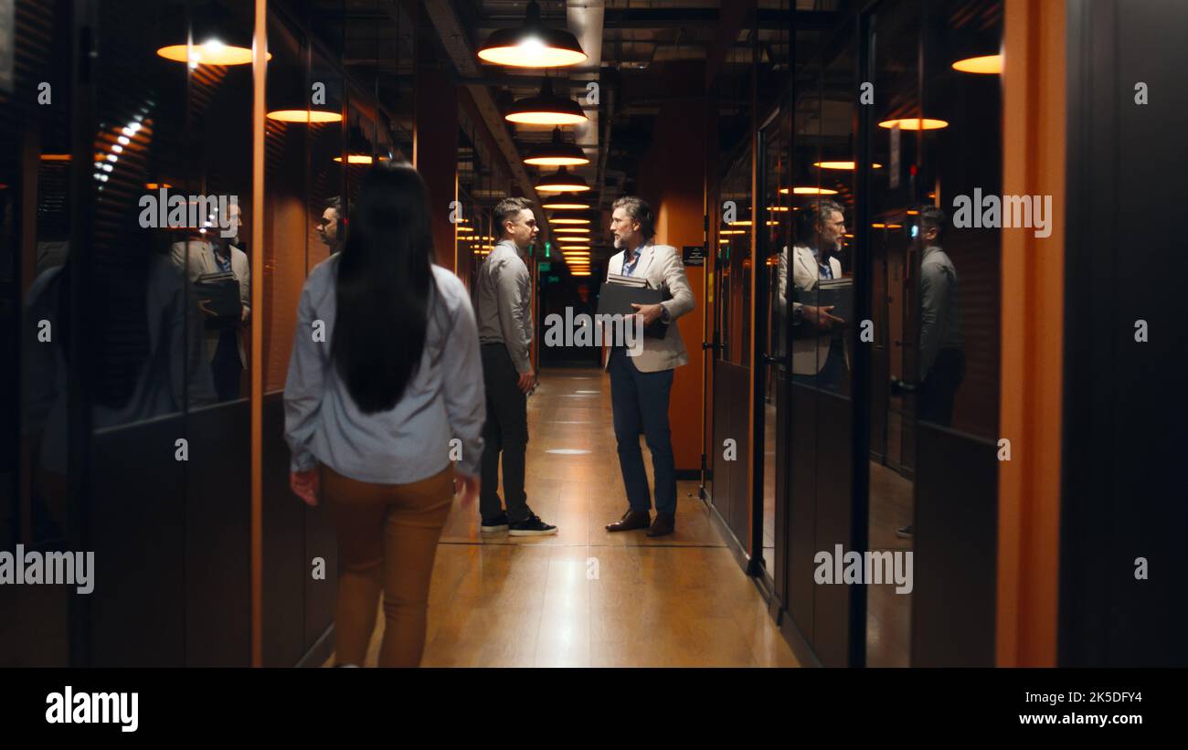 Fired upset man in suit standing in office hallway, holding box with ...