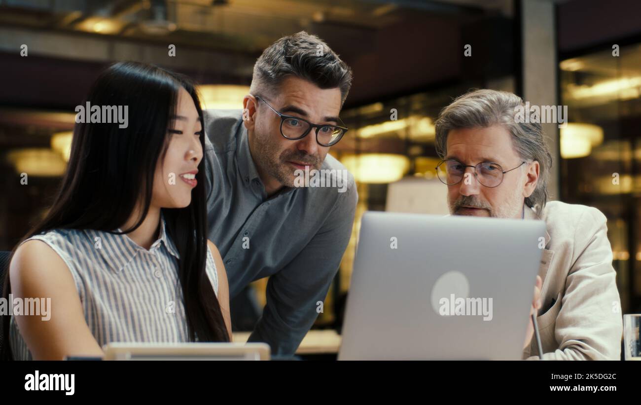 Multi-ethnic office coworkers having business meeting in modern office, using laptop ...
