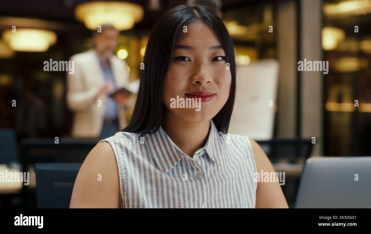 Asian businesswoman looking at the camera, working on business strategy or website design in ...