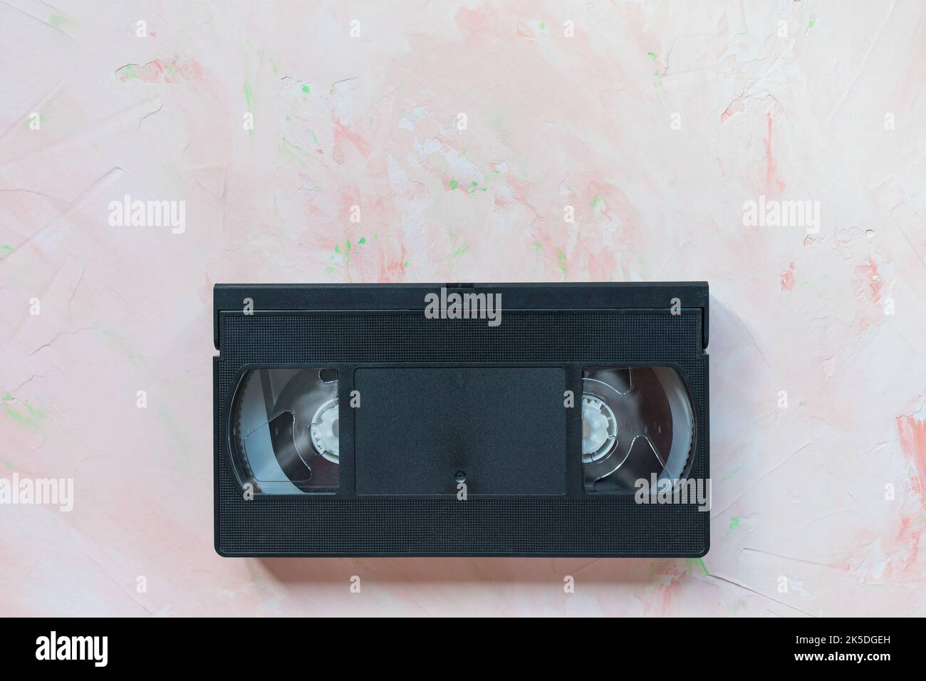 Black vintage VHS video tape on pink. Retro minimalist background, copy ...