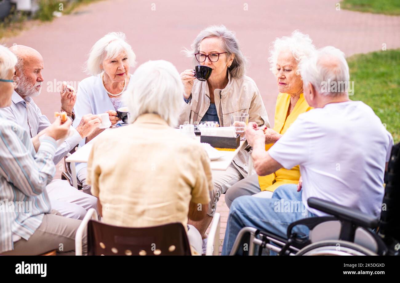 Group of happy elderly people bonding outdoors at the bar cafeteria ...