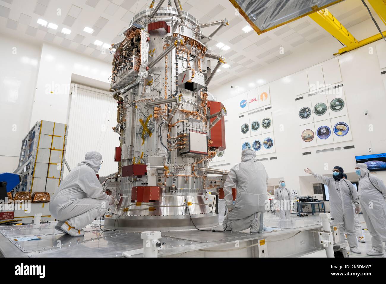 Engineers and technicians work on the towering main body of NASA's ...