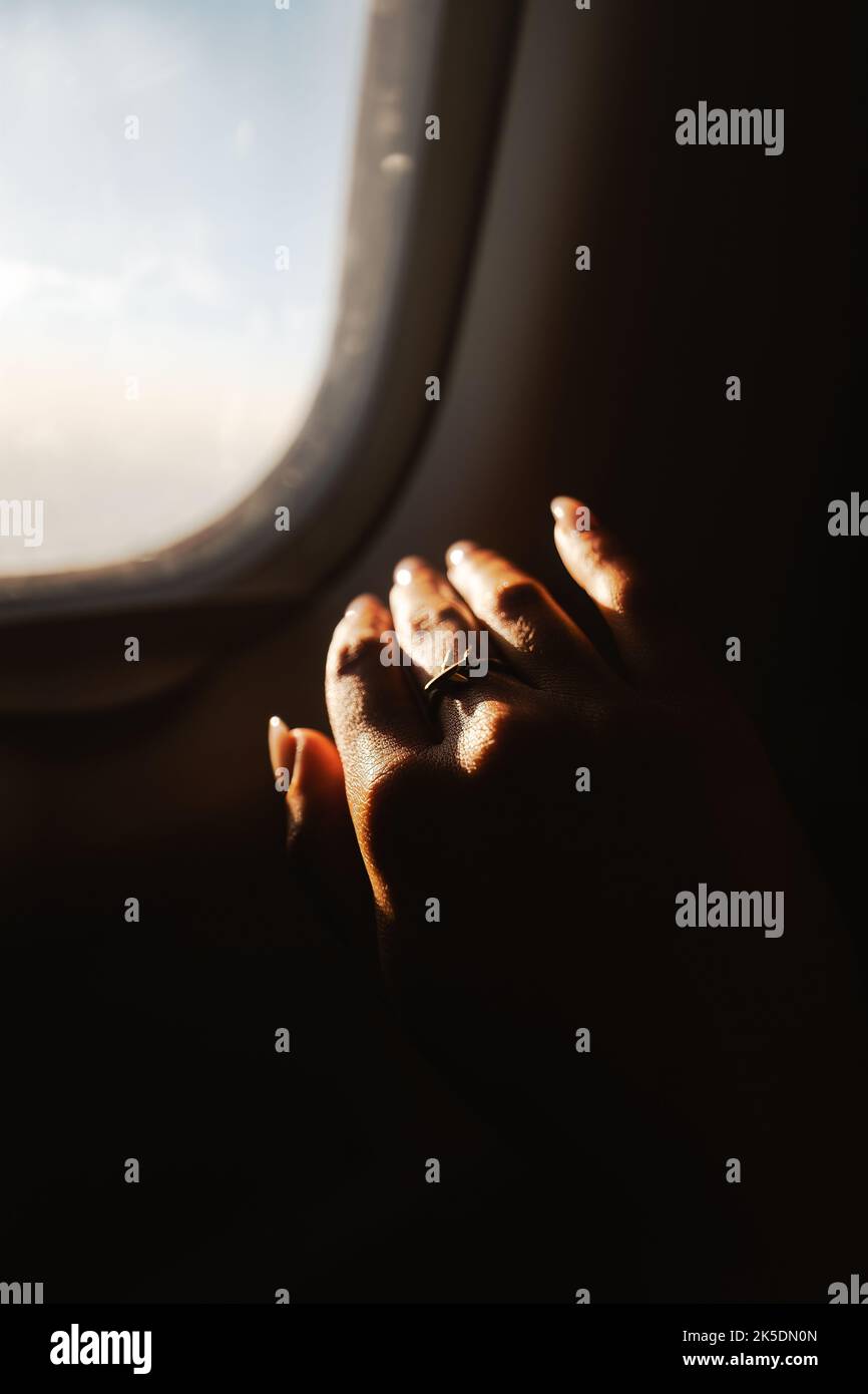 A vertical closeup of a female hand with a plane ring on the ring ...