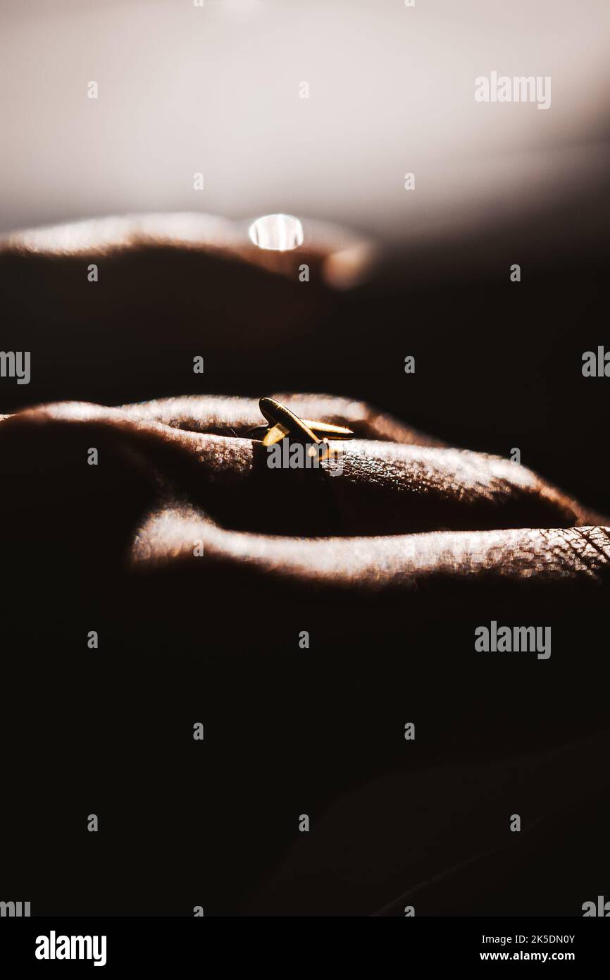 A vertical closeup of a plane ring on the ring finger, blurred ...