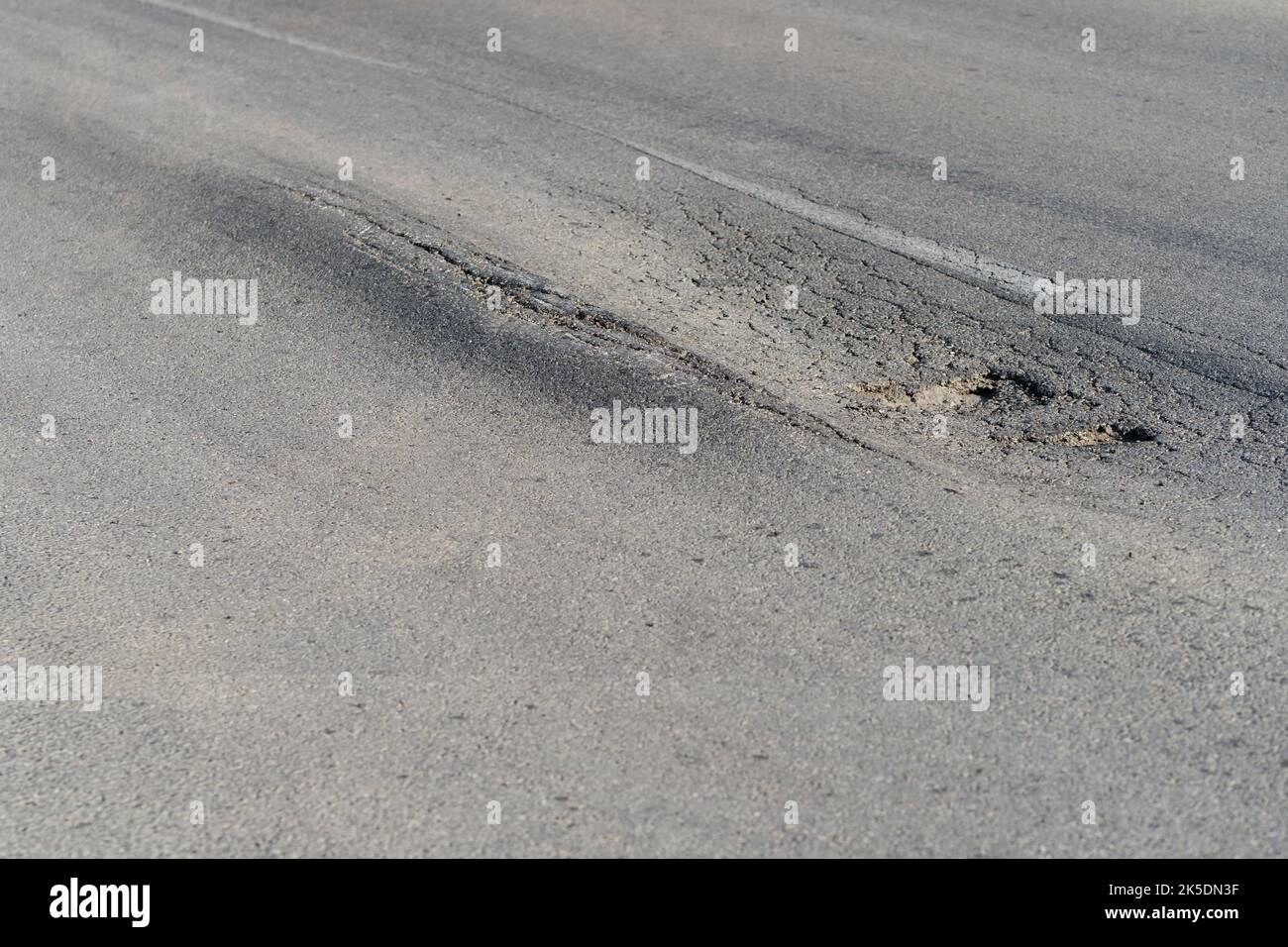 Deformed asphalt surface with potholes caused by heavy overloaded ...