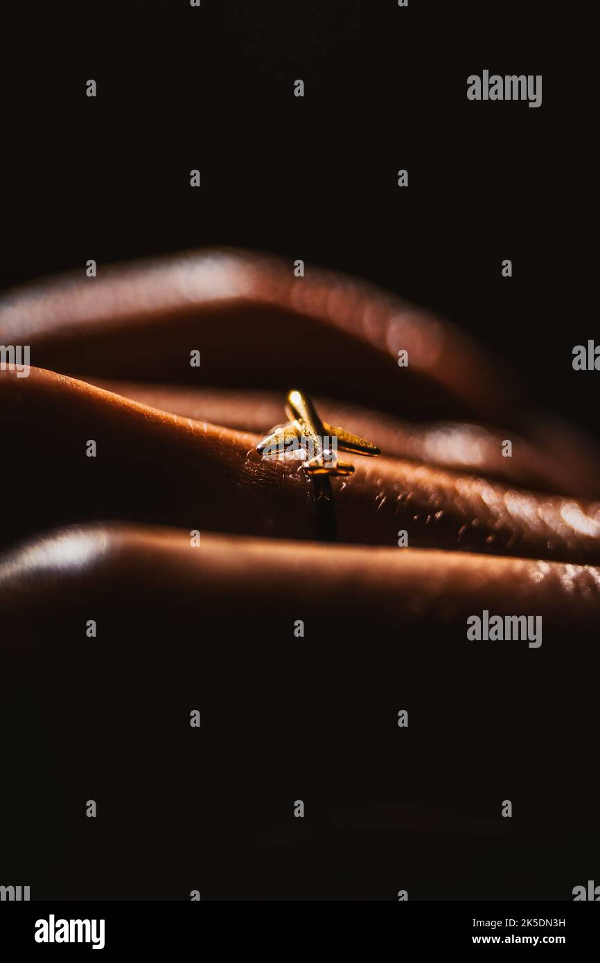 A vertical closeup of a plane ring on the ring finger, blurred ...