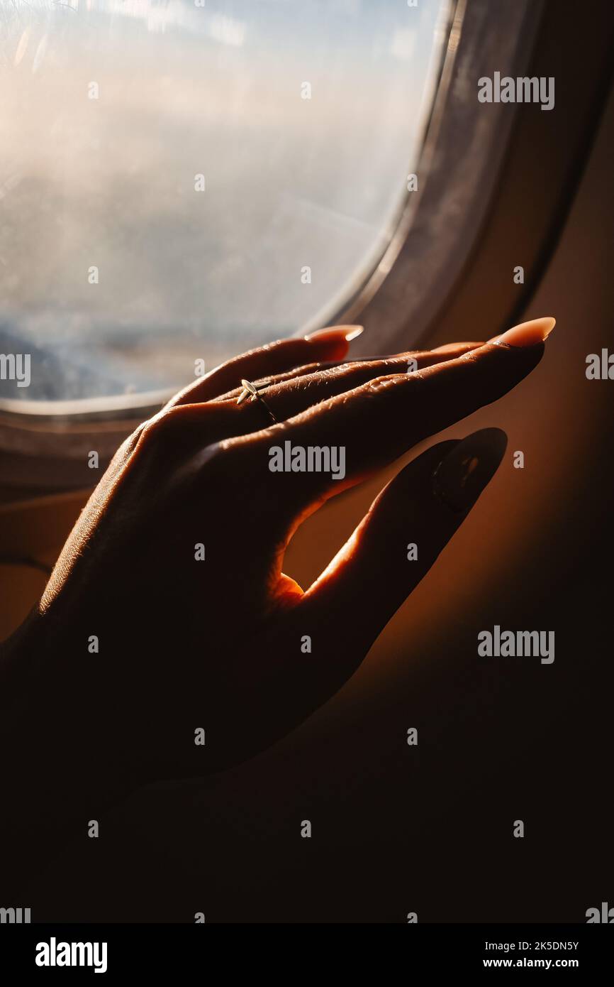 A vertical closeup of a female hand with a plane ring on the ring ...